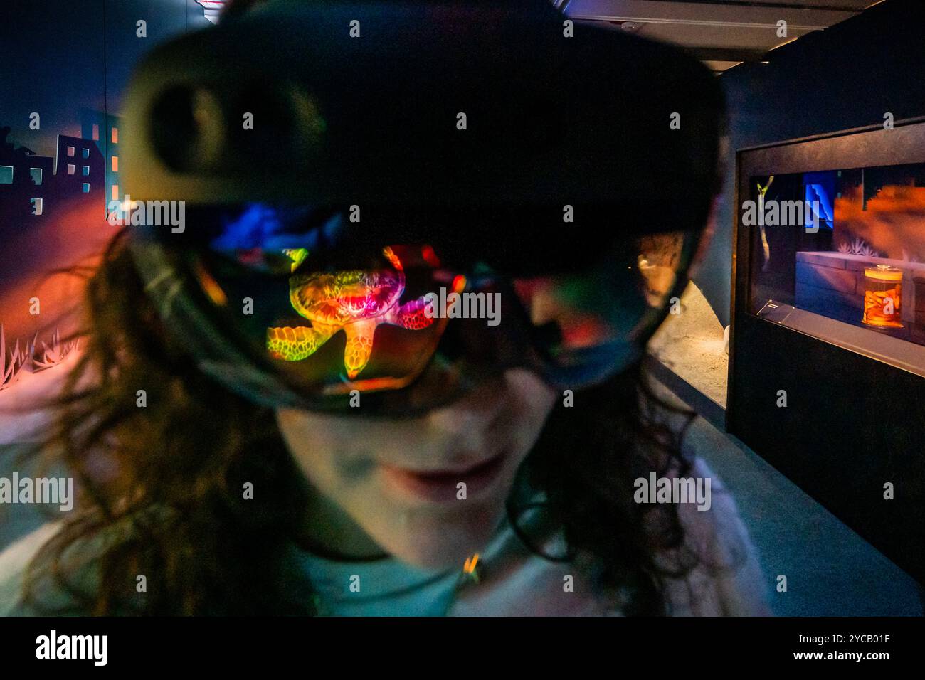 London, UK. 22nd Oct, 2024. A visitor watches a sea turtle swim in its ...