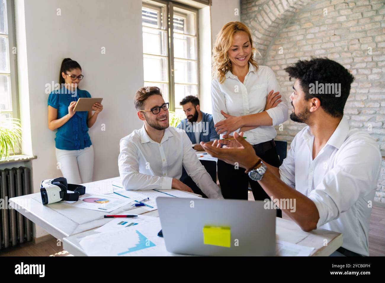 Group of young multi-ethnic startup business team collaborating on project in modern office ...