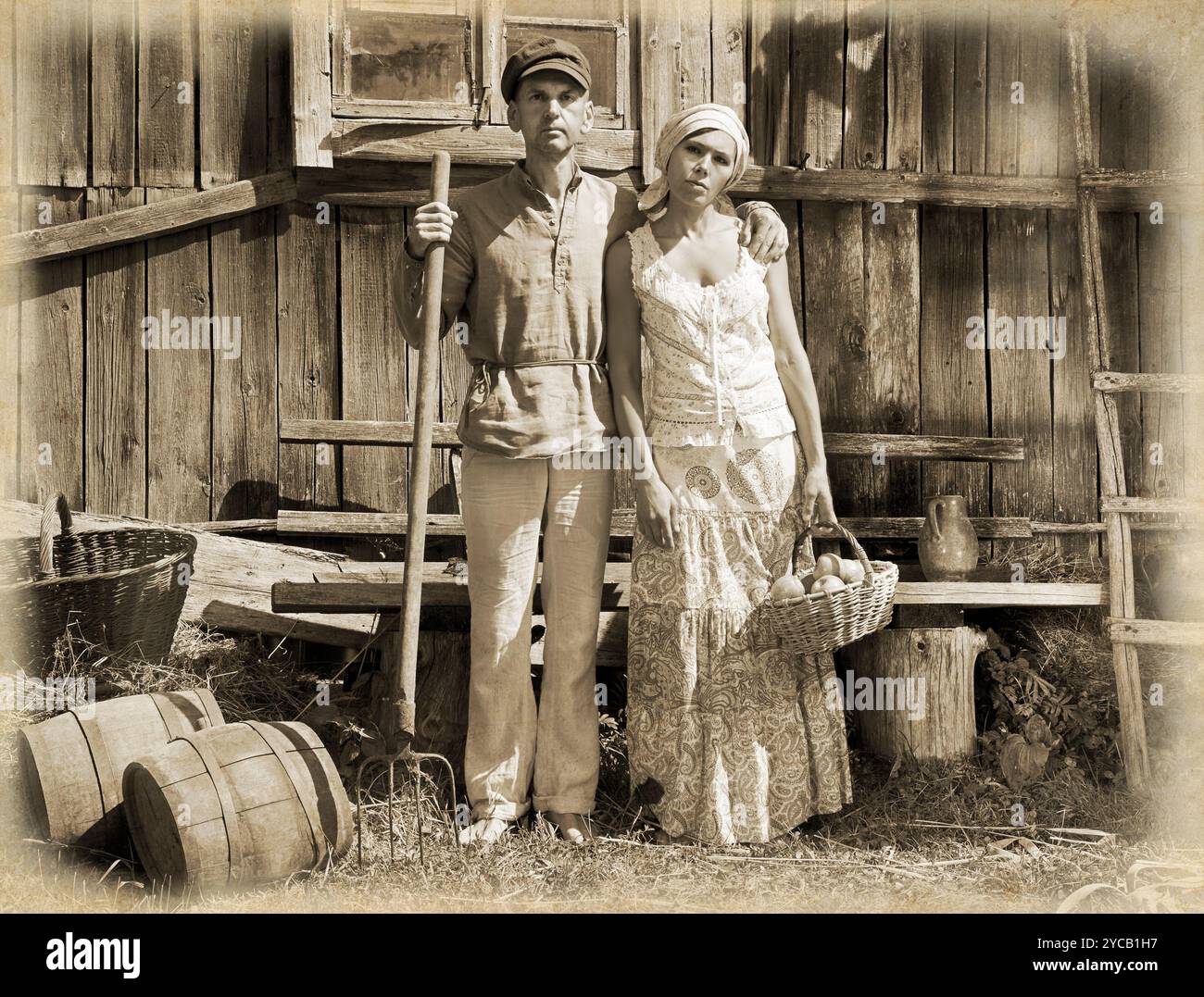 Couple in a stiff, old classic retro pose, standing in front of wooden ...