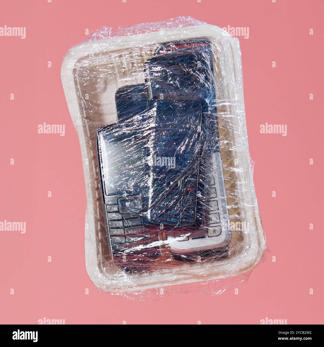 Old mobile phones tightly wrapped in plastic, representing transition ...