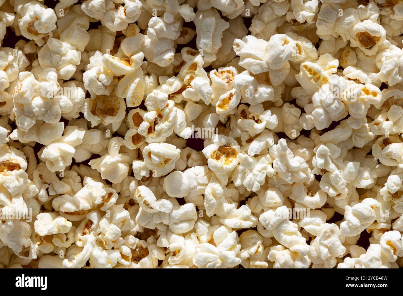 A close-up image displaying the texture of freshly popped popcorn ...