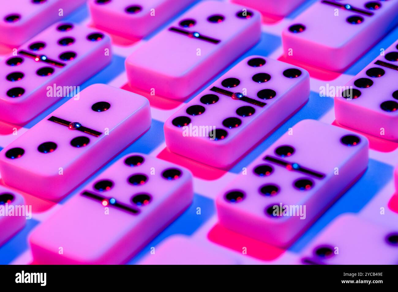 Pink domino pieces arranged neatly on a blue surface, evoking nostalgia ...