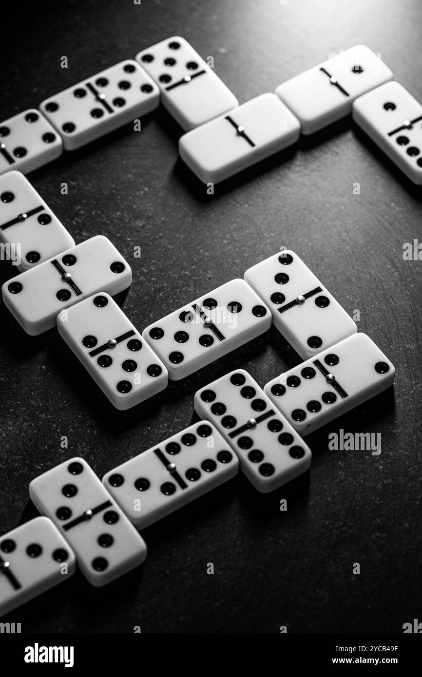 Black and white image capturing a nostalgic game of dominoes scattered ...