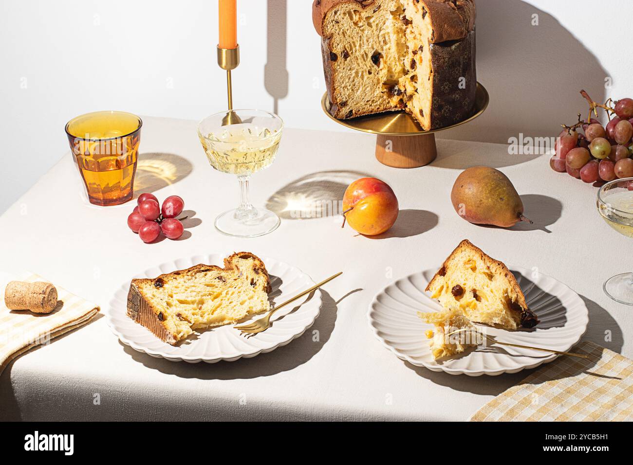 A luxurious table setting displays a traditional Italian Panettone ...