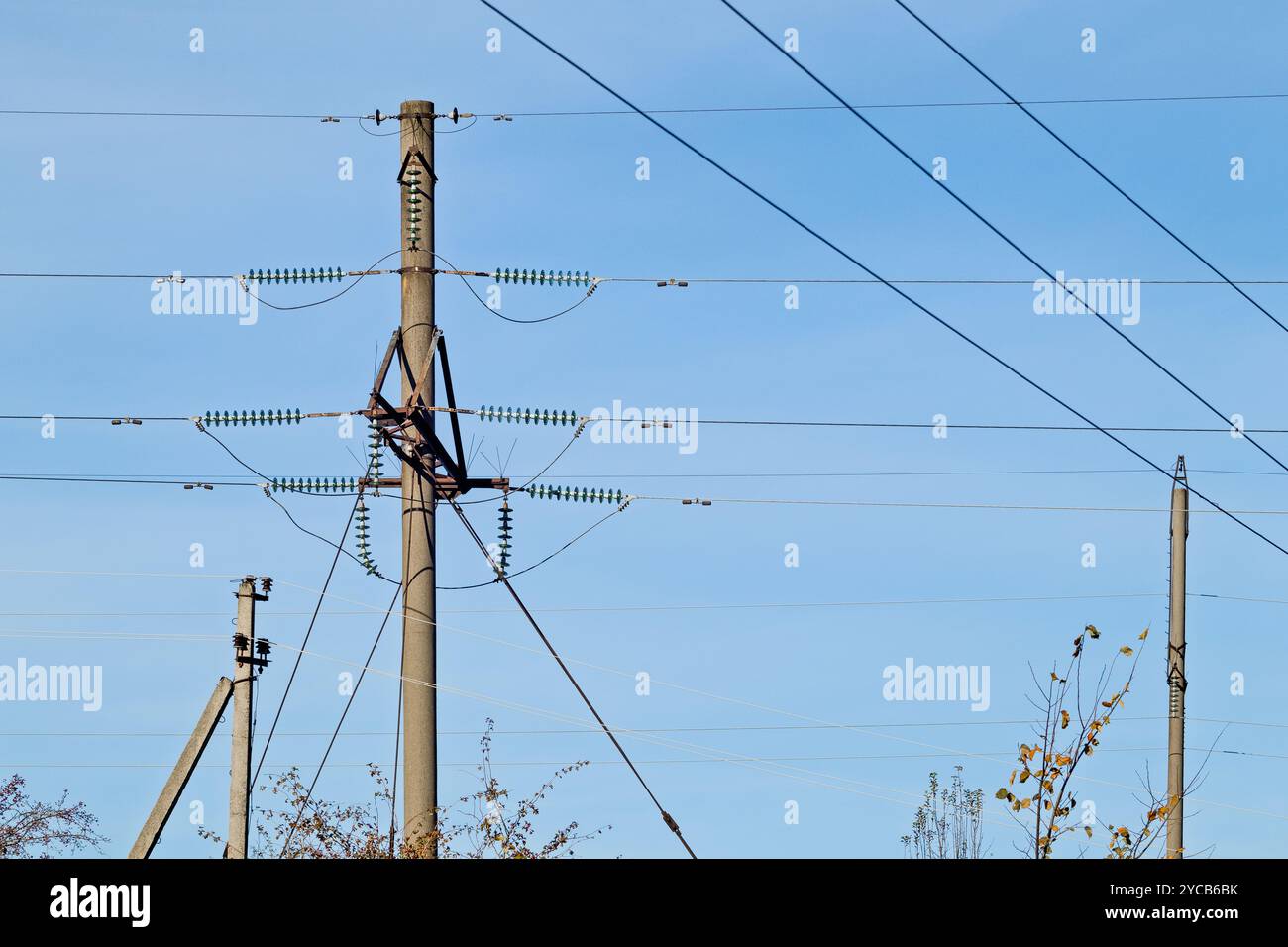 Power lines against a clear blue sky. Close-up of poles and power lines ...