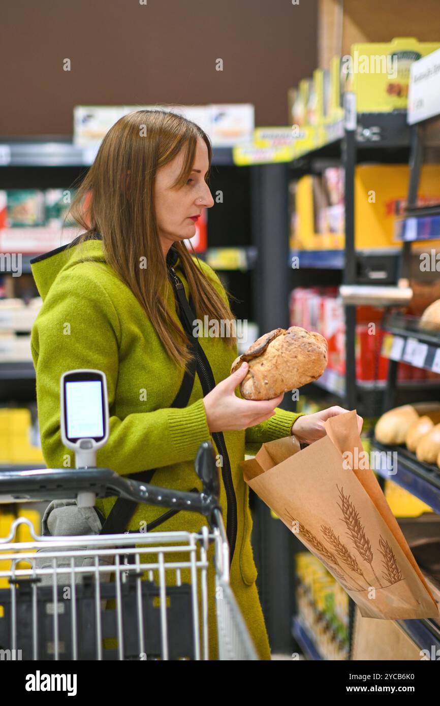 Customer is scanning a loaf of bread with a self-scanning device ...