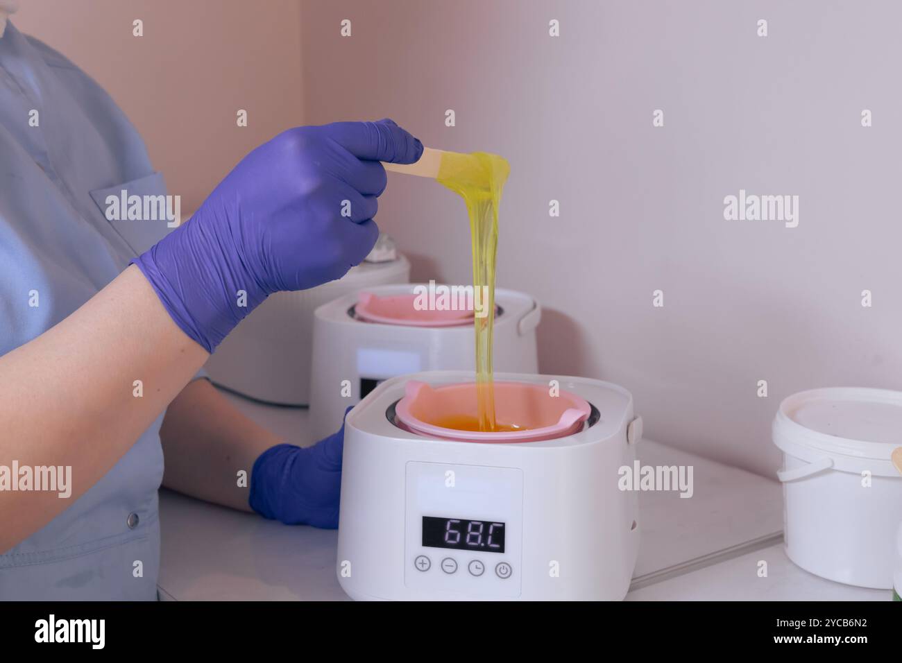 Waxing process in a beauty salon with warm wax and an applicator in use ...