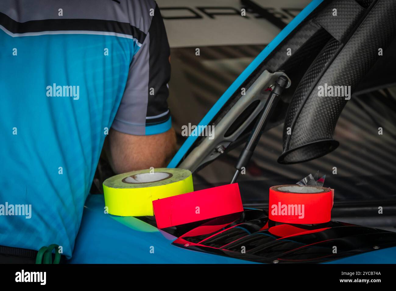 An engineer meticulously inspects the race car, fine-tuning key ... An engineer meticulously inspects the race car, fine-tuning key ...