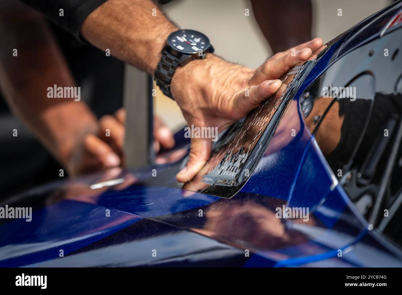 An engineer meticulously inspects the race car, fine-tuning key ...