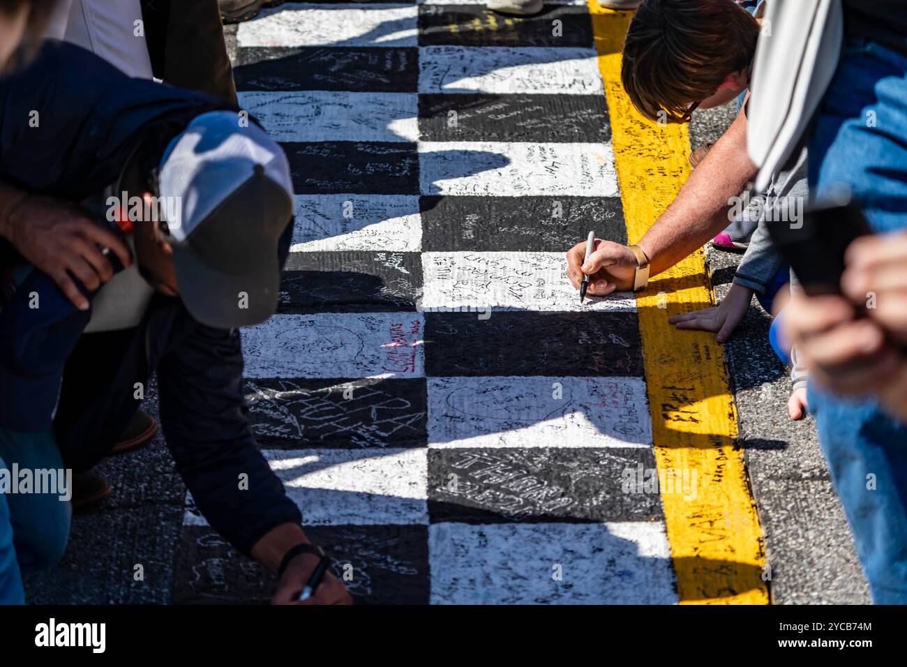 Before every big racing event, fans sign the start/finish line, leaving ...