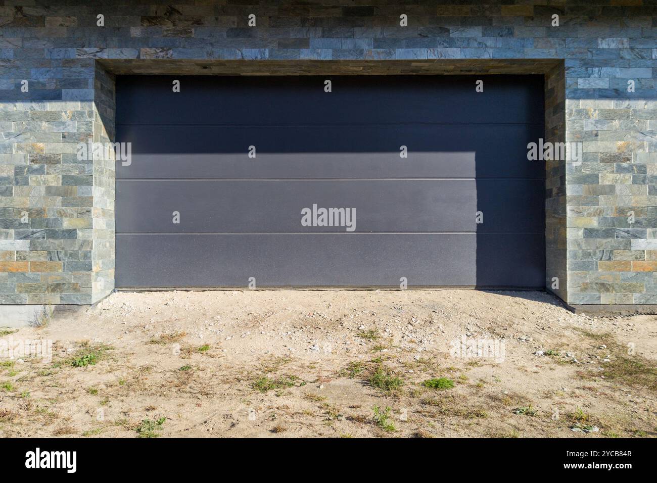 Modern Garage Door with Stone Wall Surround Stock Photo - Alamy