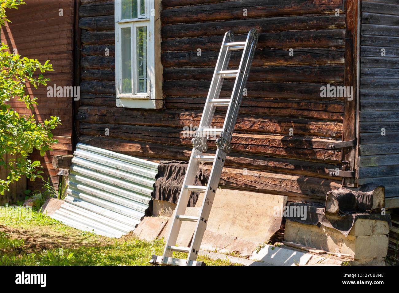 old wooden house restoration and expandable ladder leaned against the ...