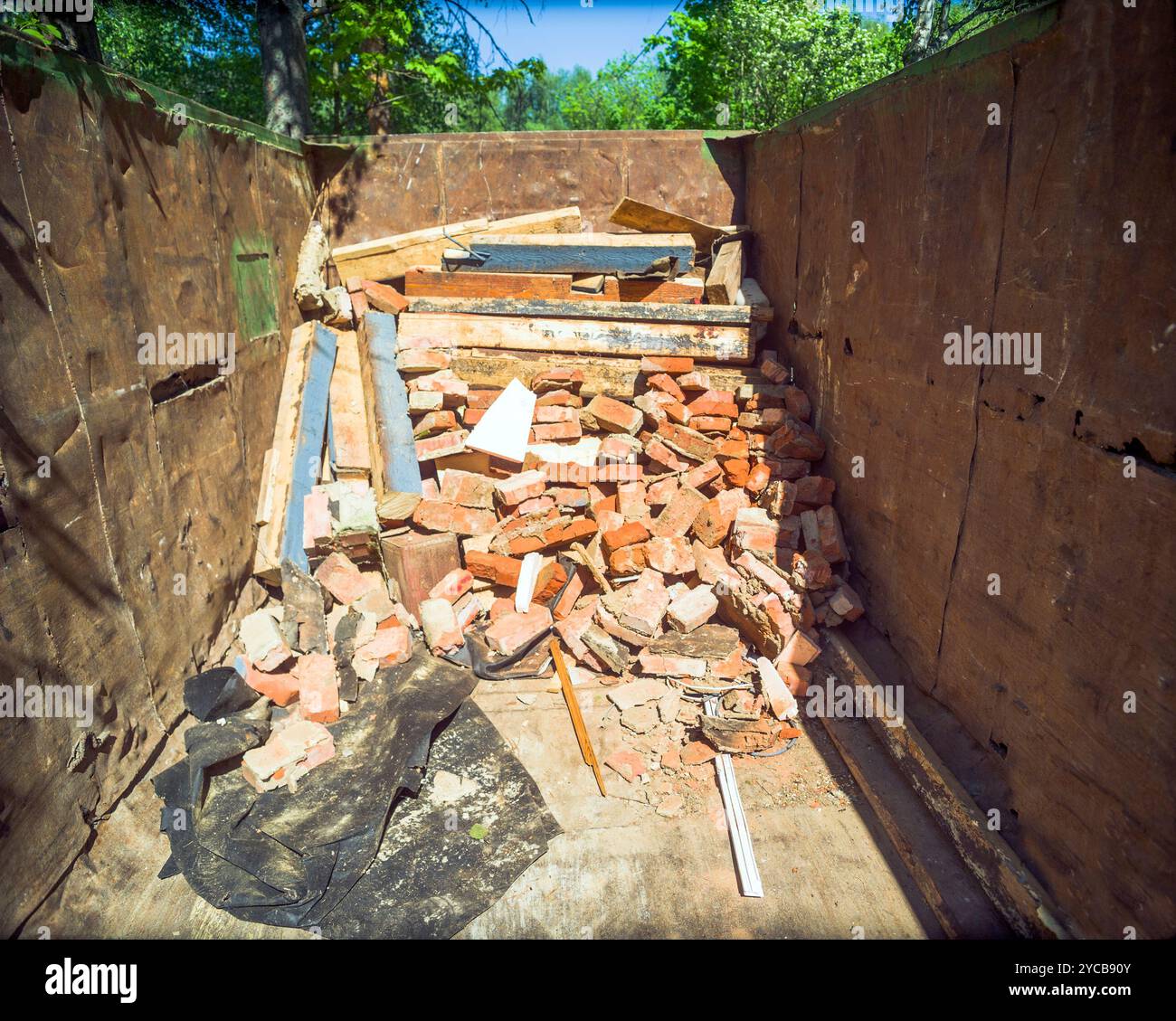 pile of rubble bricks and concrete in big metal container, outdoor shot ...
