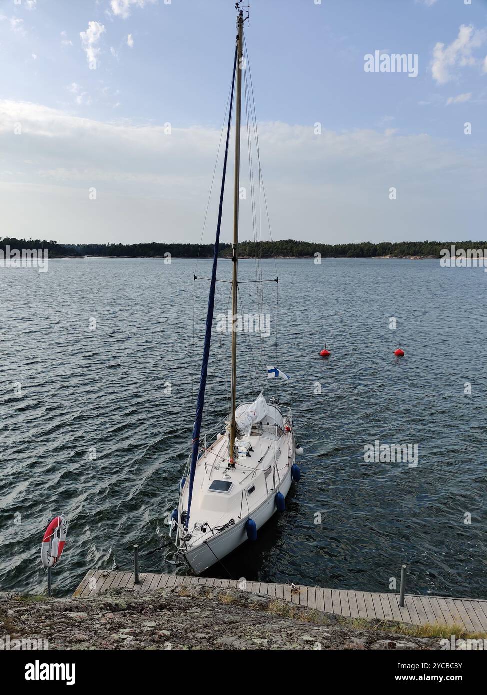 Sailboat tied to a mooring buoy at the harbor of the island in Finland ...