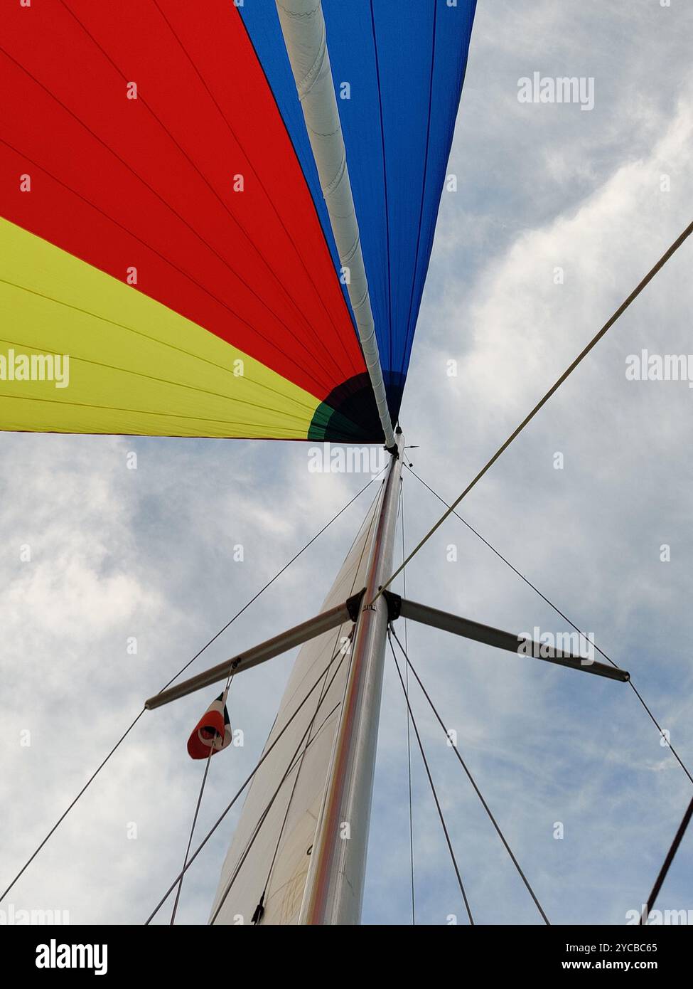 Colorful gennaker sail of a sailing yacht in the wind, sailing on the ...
