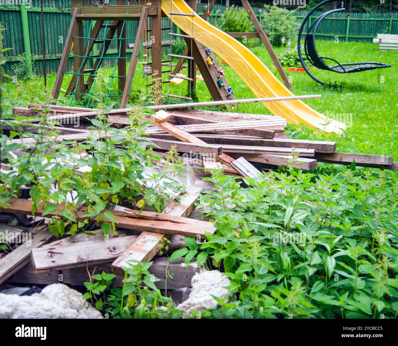 garbage in overgrown park and children slide, outdoor shot, no people ...