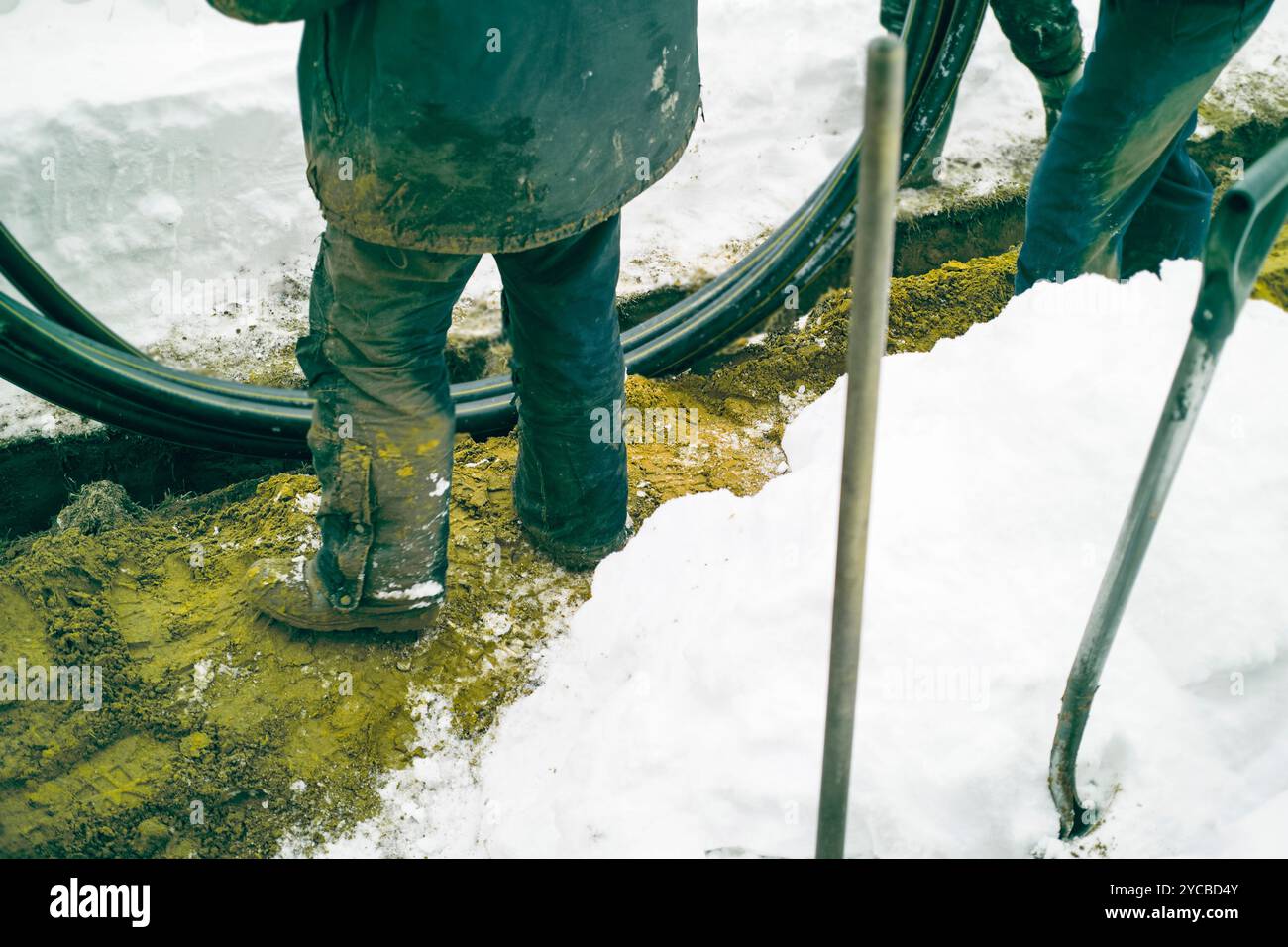 workers digging a trench for electrical or gas cable, winter scenery ...