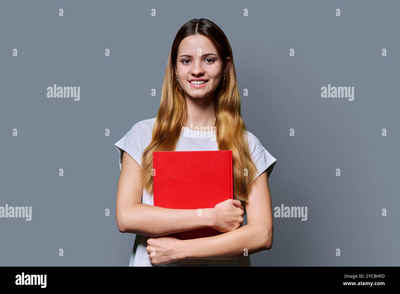 Portrait of teenager student girl holding notebook looking at camera on ...