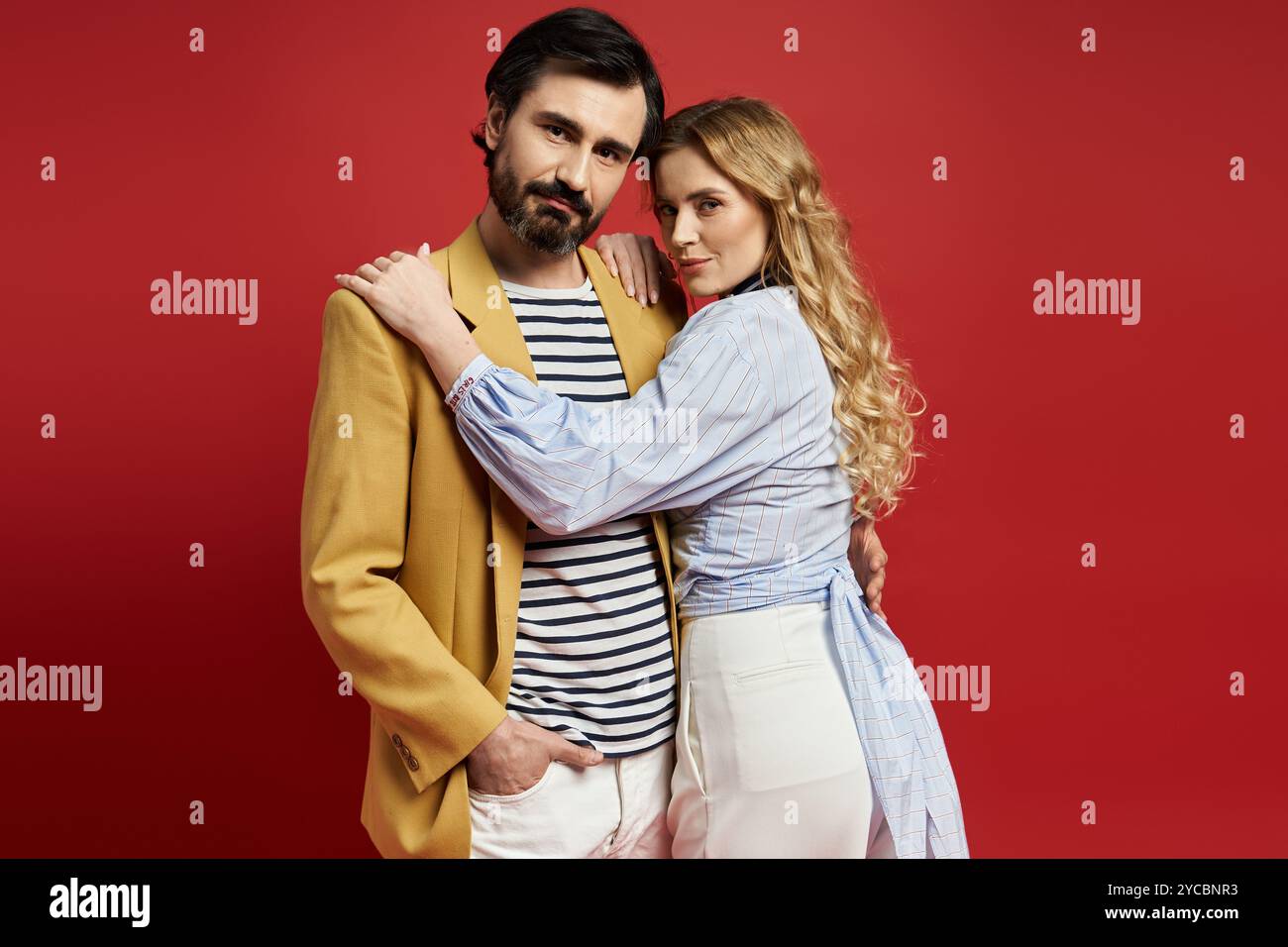 A couple embraces thoughtfully, showcasing their fashion choices with a ...