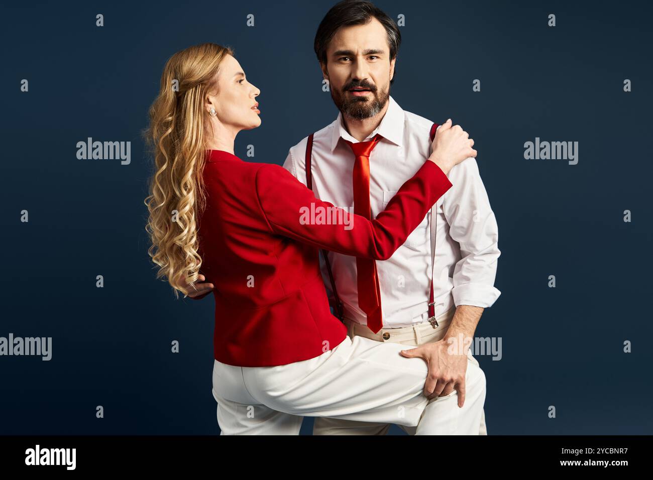 A confident middle aged couple shares a playful moment in a dance pose ...