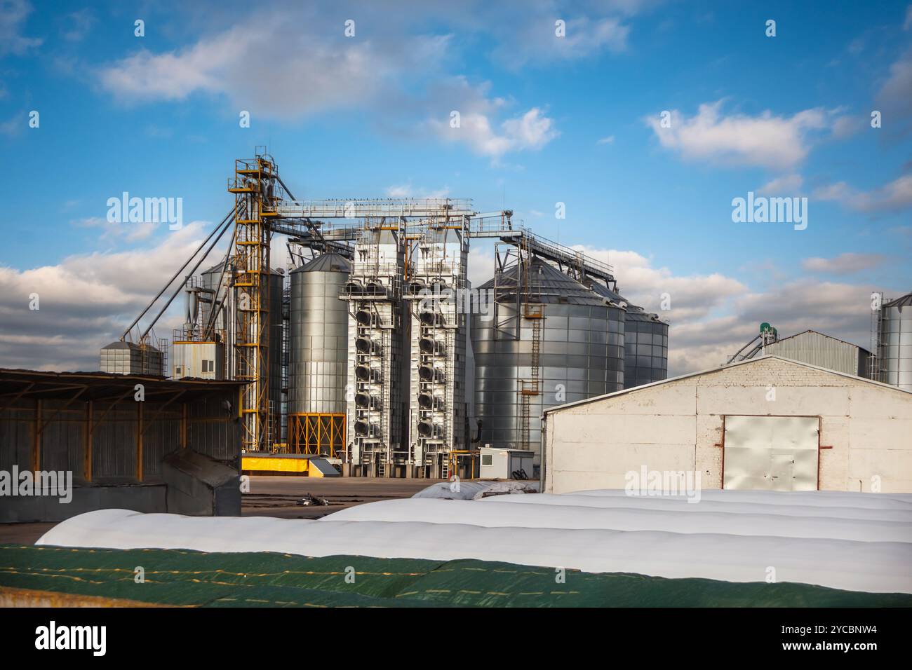large grain elevator with multiple cylindrical metal silos, structural ...