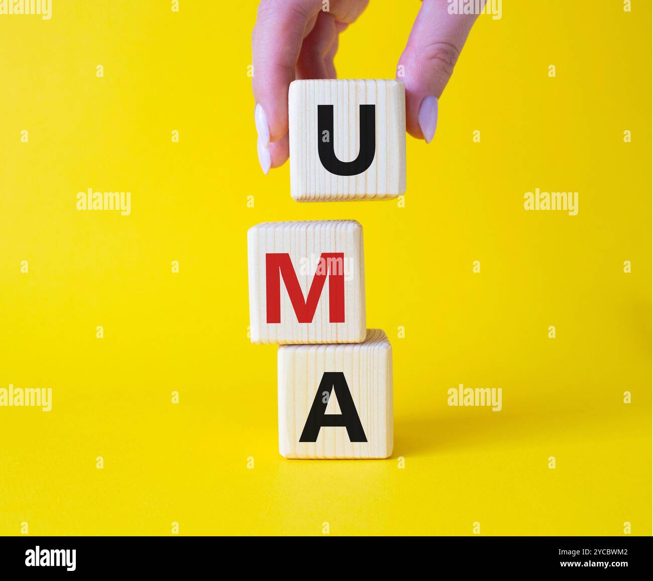UMA - Unified Managed Account. Wooden cubes with word UMA. Businessman ...
