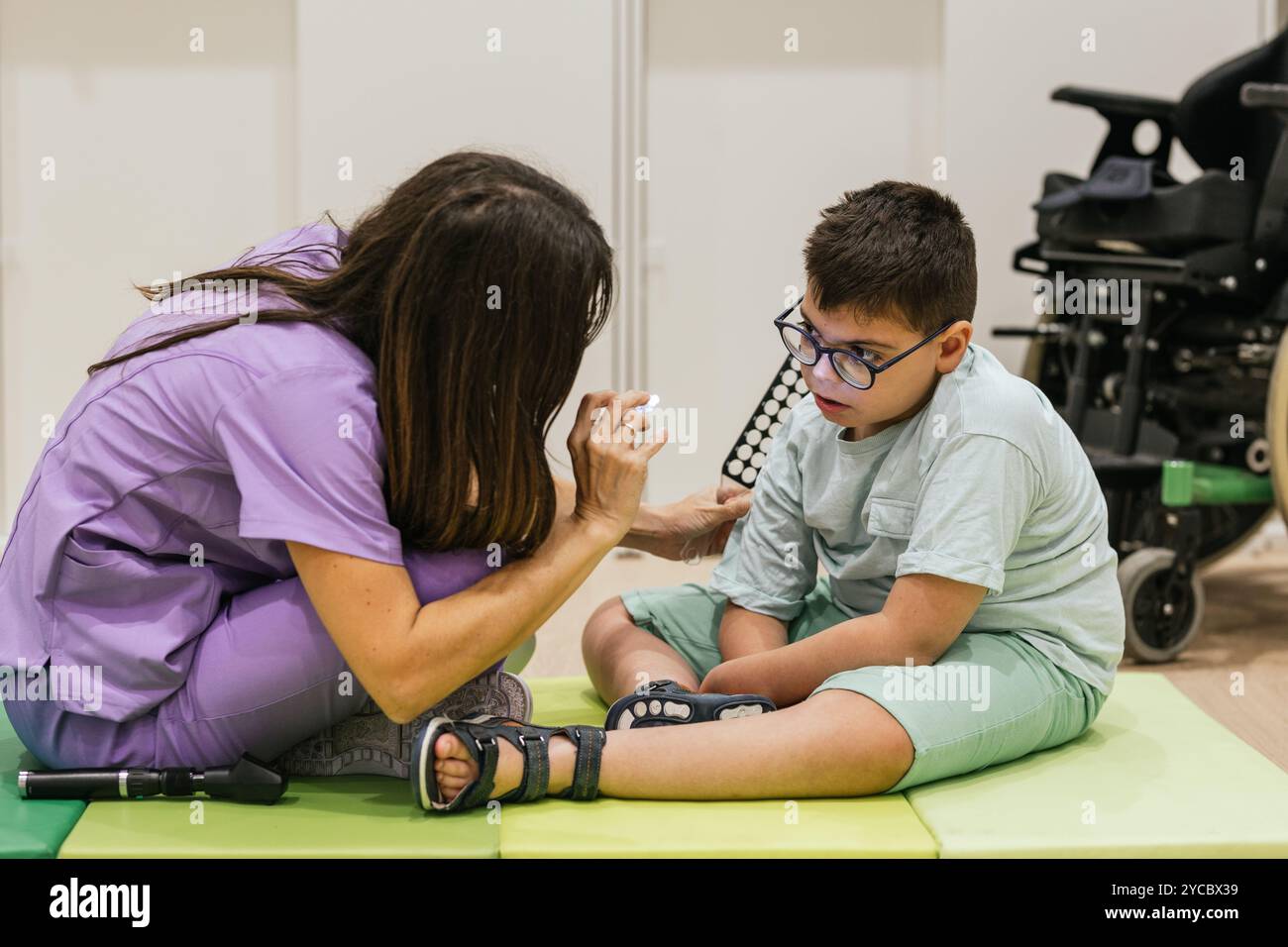 Female optometrist performing eye examination on child with cerebral ...