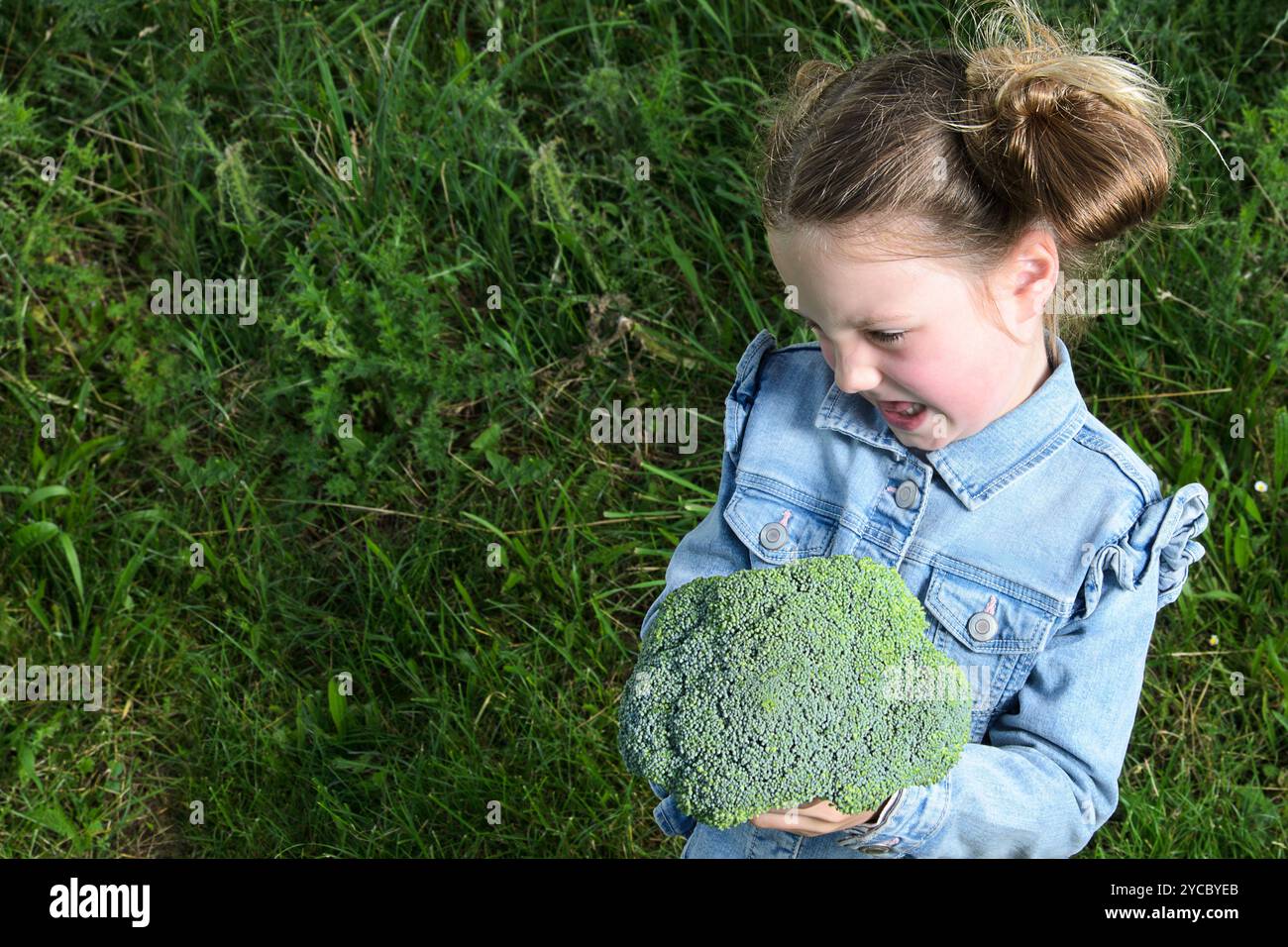 The child girl looks at the broccoli with disgust Stock Photo - Alamy