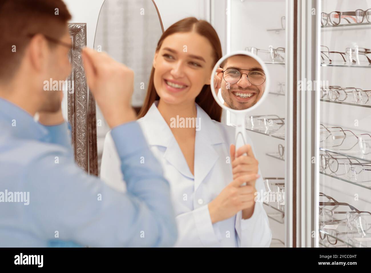Optometrist helping man to choose correction glasses Stock Photo - Alamy