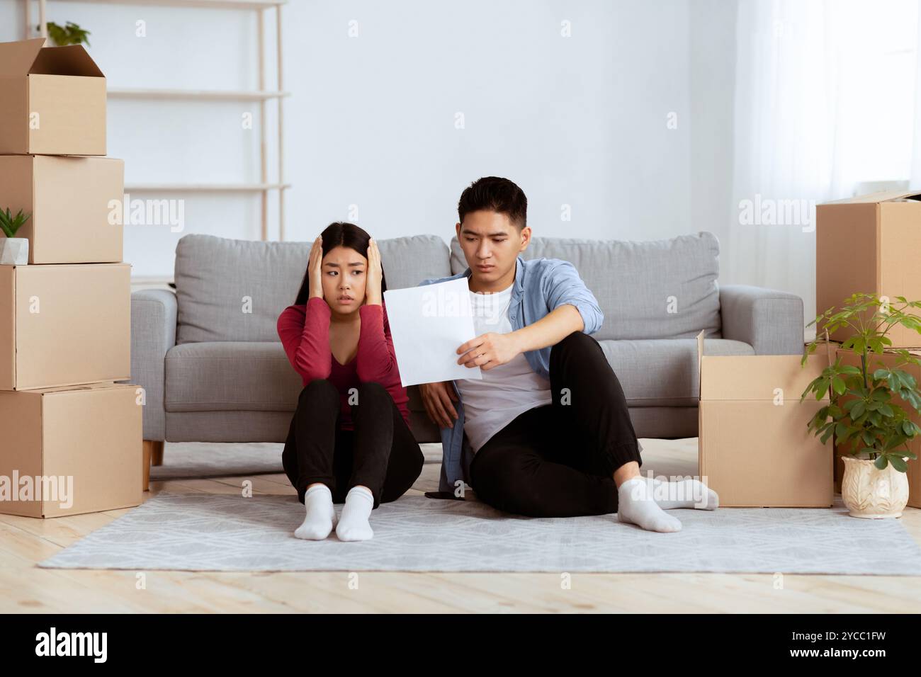 Asian man showing his shocked wife eviction notice Stock Photo - Alamy