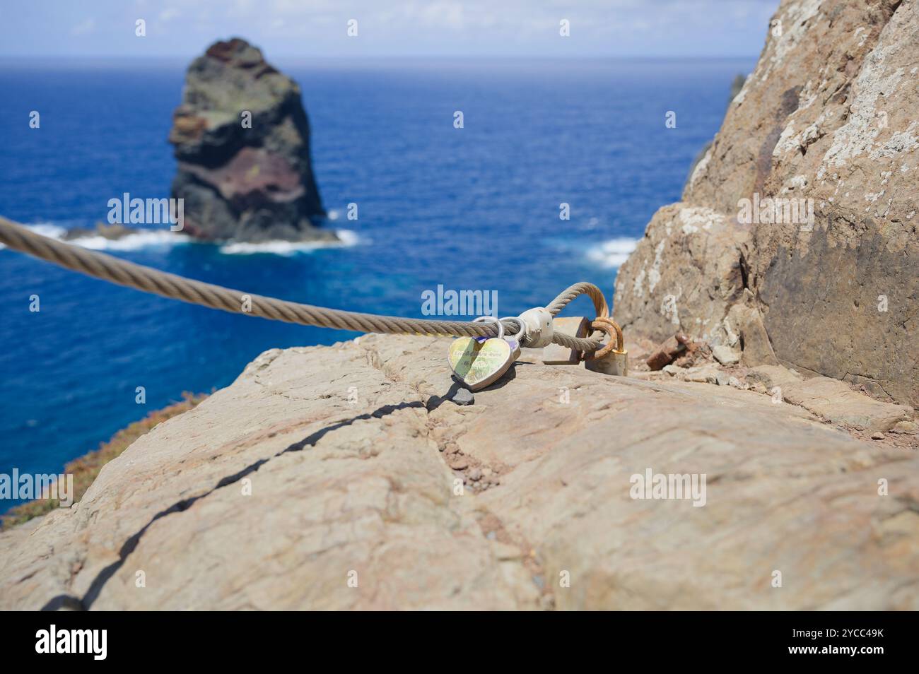 A heart-shaped lock with names engraved, fastened to a safety rope ...