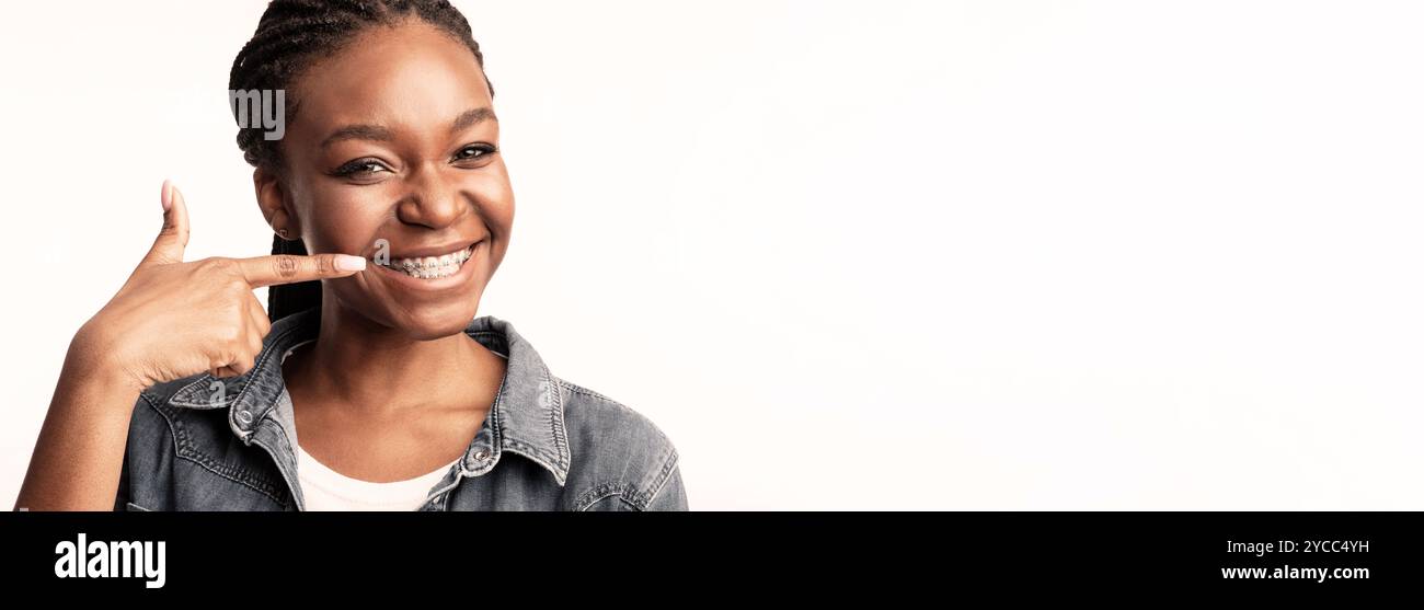 African Lady In Braces Pointing Finger At Smile, White Background Stock ...