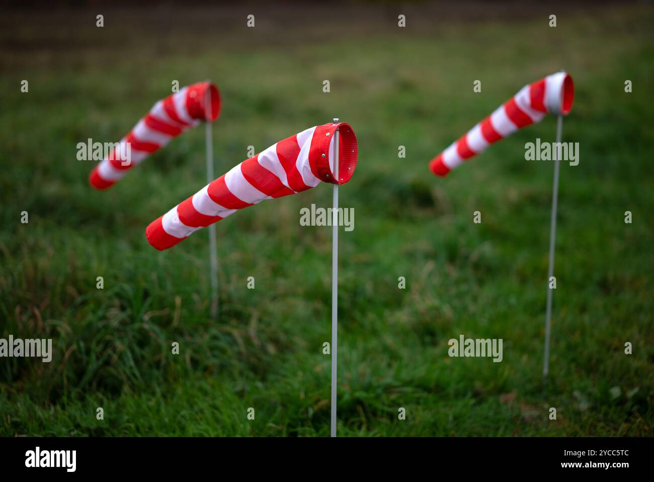three red and white windsocks in a meadow Stock Photo - Alamy