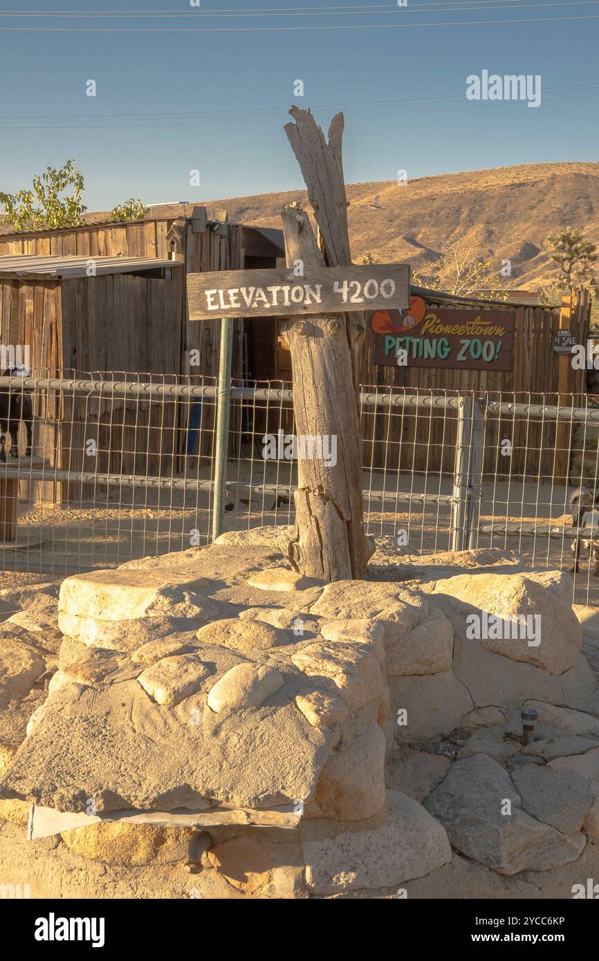 An altitude sign of 4200 feet in front of a pen for Pioneertown ...