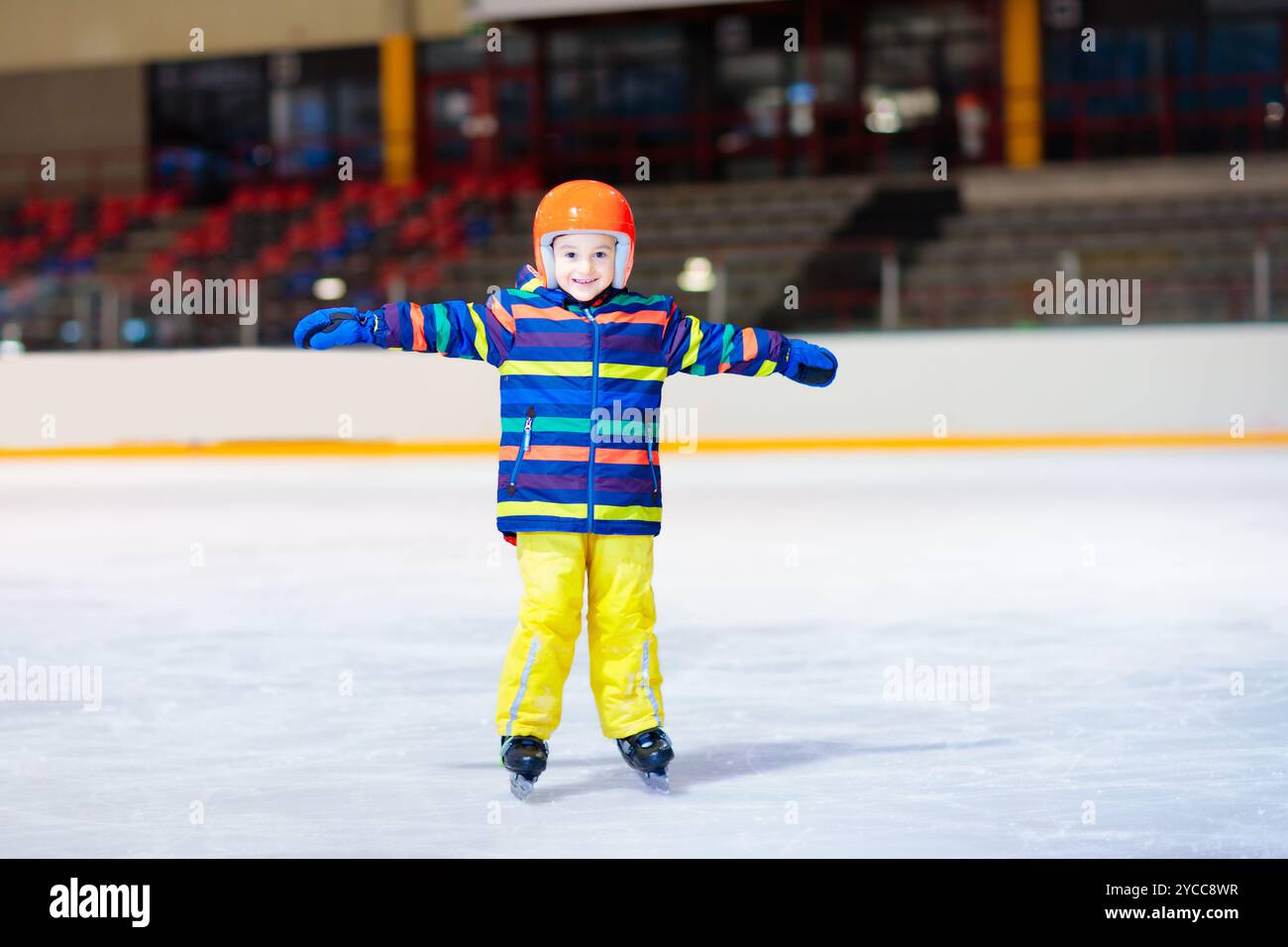 Child skating on indoor ice rink. Kids skate. Active family sport during winter vacation and ...