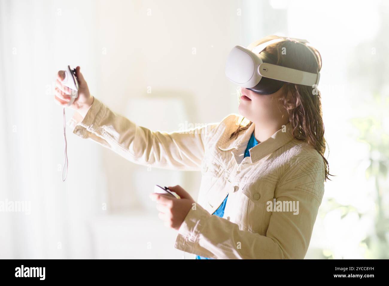 Child in virtual reality goggles. VR set for kids. Teenage girl playing ...