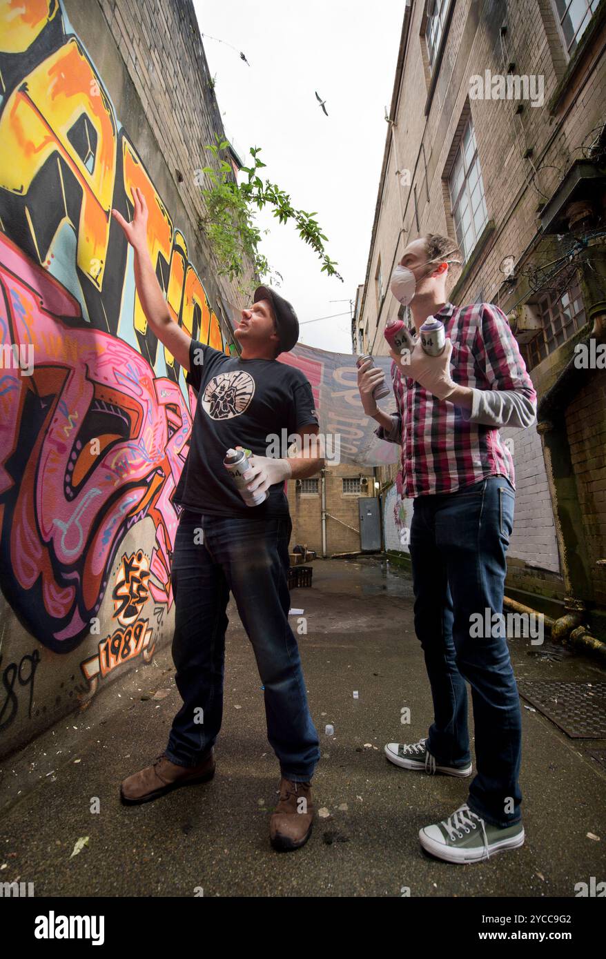 The artist Rob Wheeler (left) sketching designs during a graffiti ...