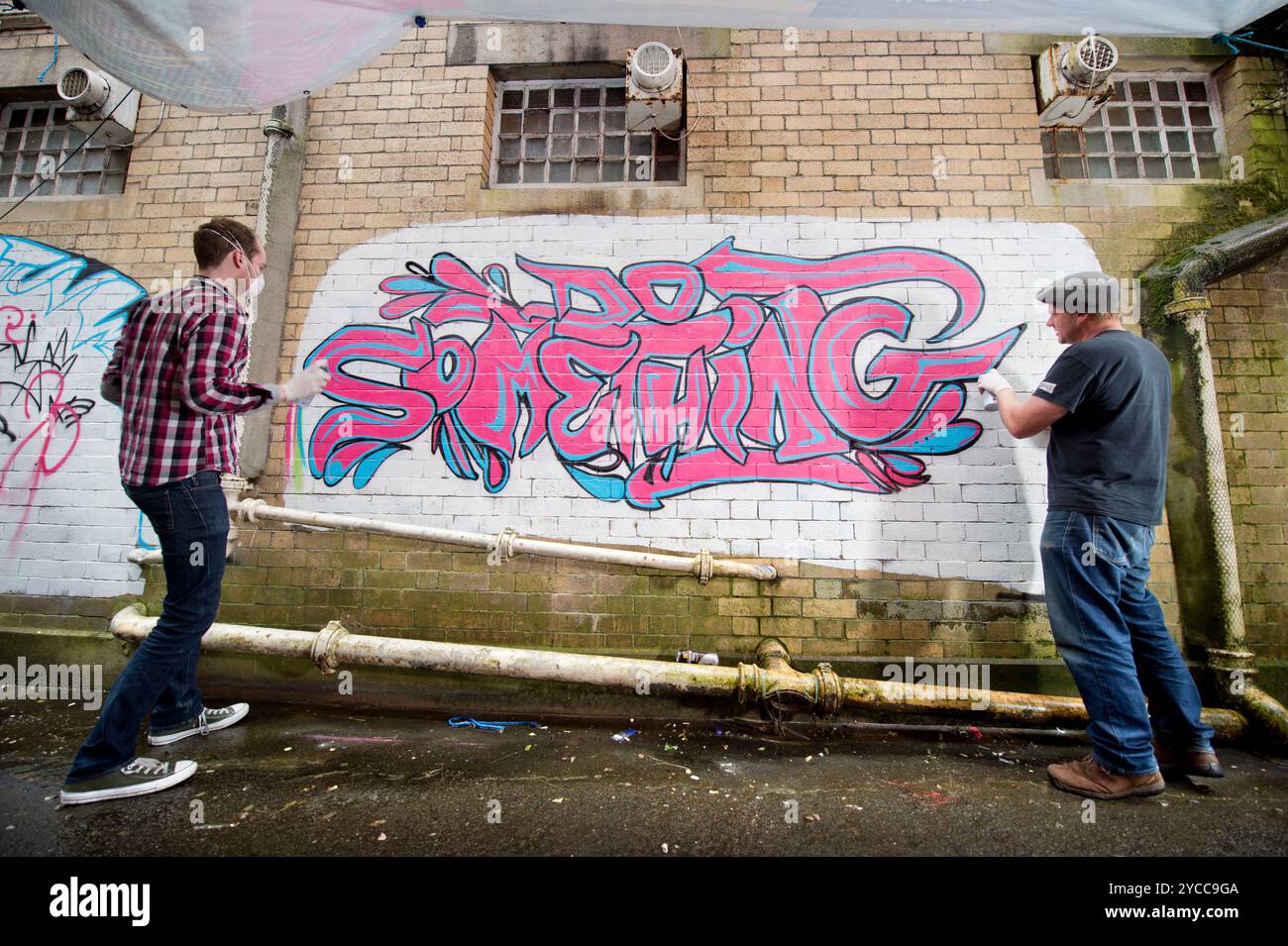 The artist Rob Wheeler (right) sketching designs during a graffiti ...