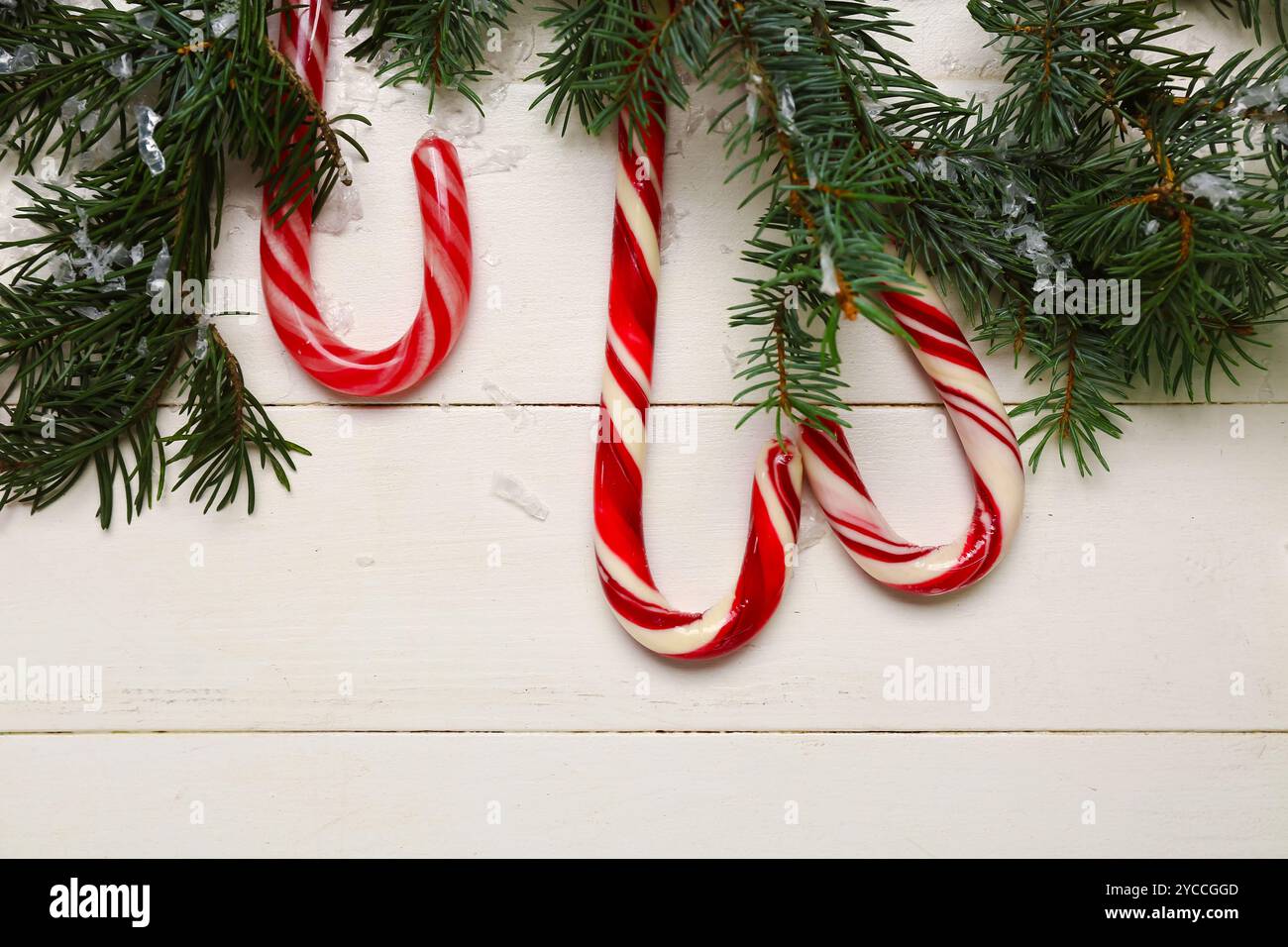 Christmas candy canes and fir branches on white background Stock Photo - Alamy