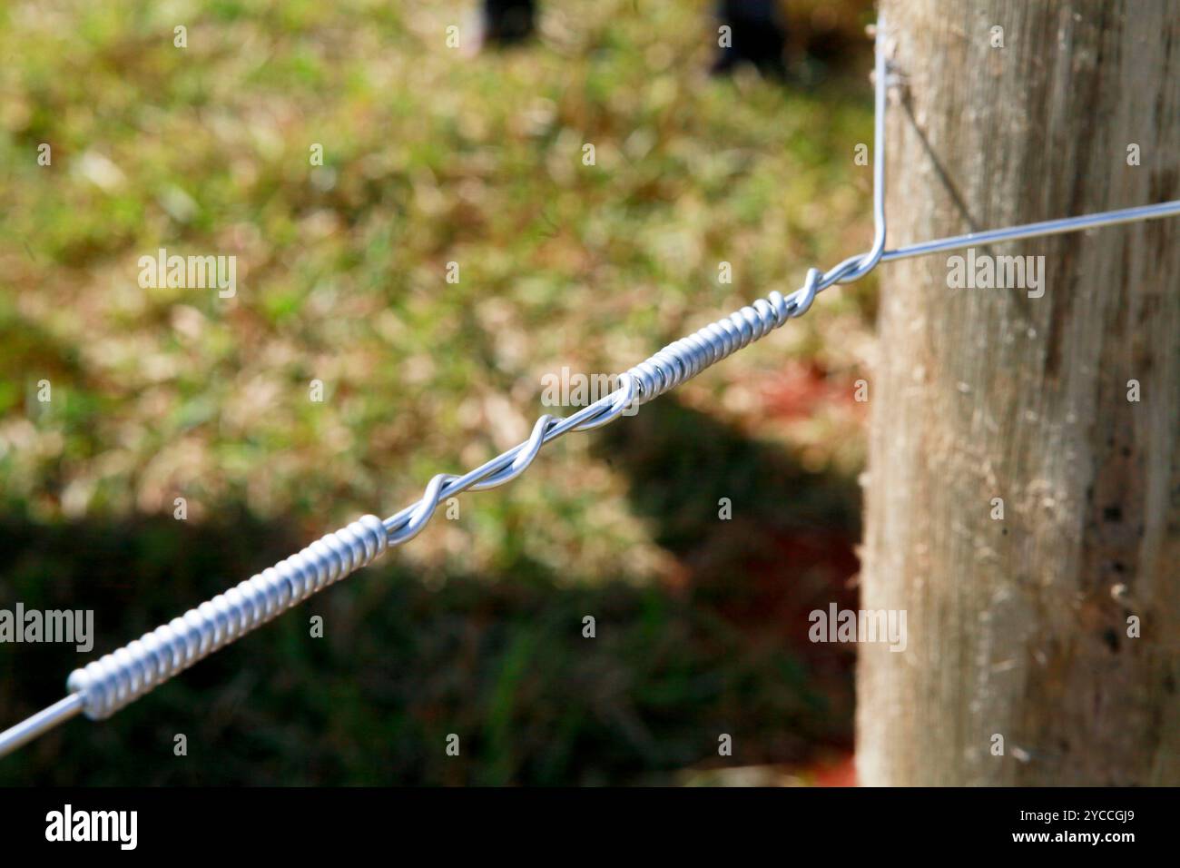 Detail of a new metal wire fence with a grass background on a farm in ...