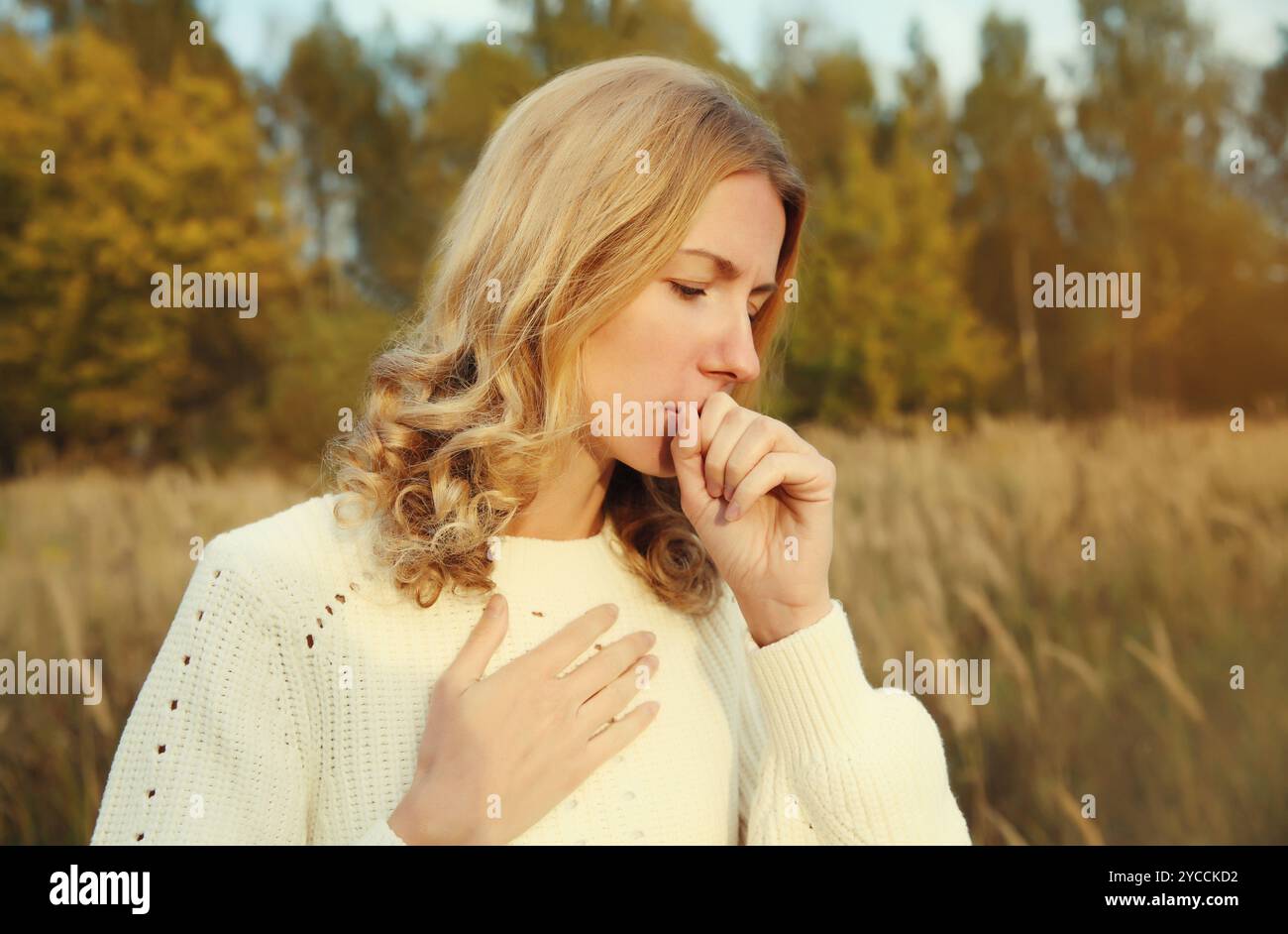 Cold and health, sick young woman coughing outdoors in autumn park ...