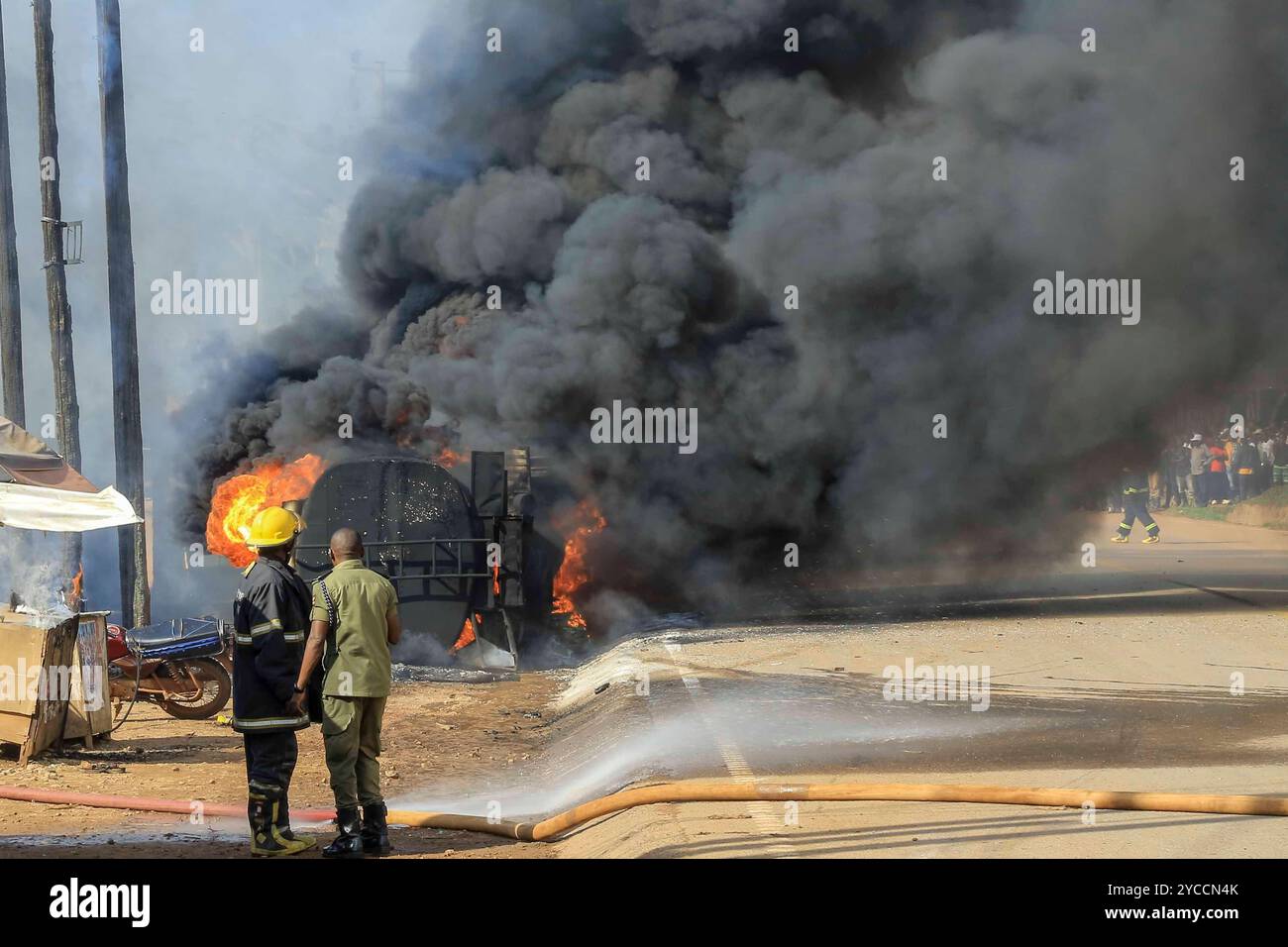 Firefighters try to contain a fire after a fuel truck exploded next to ...