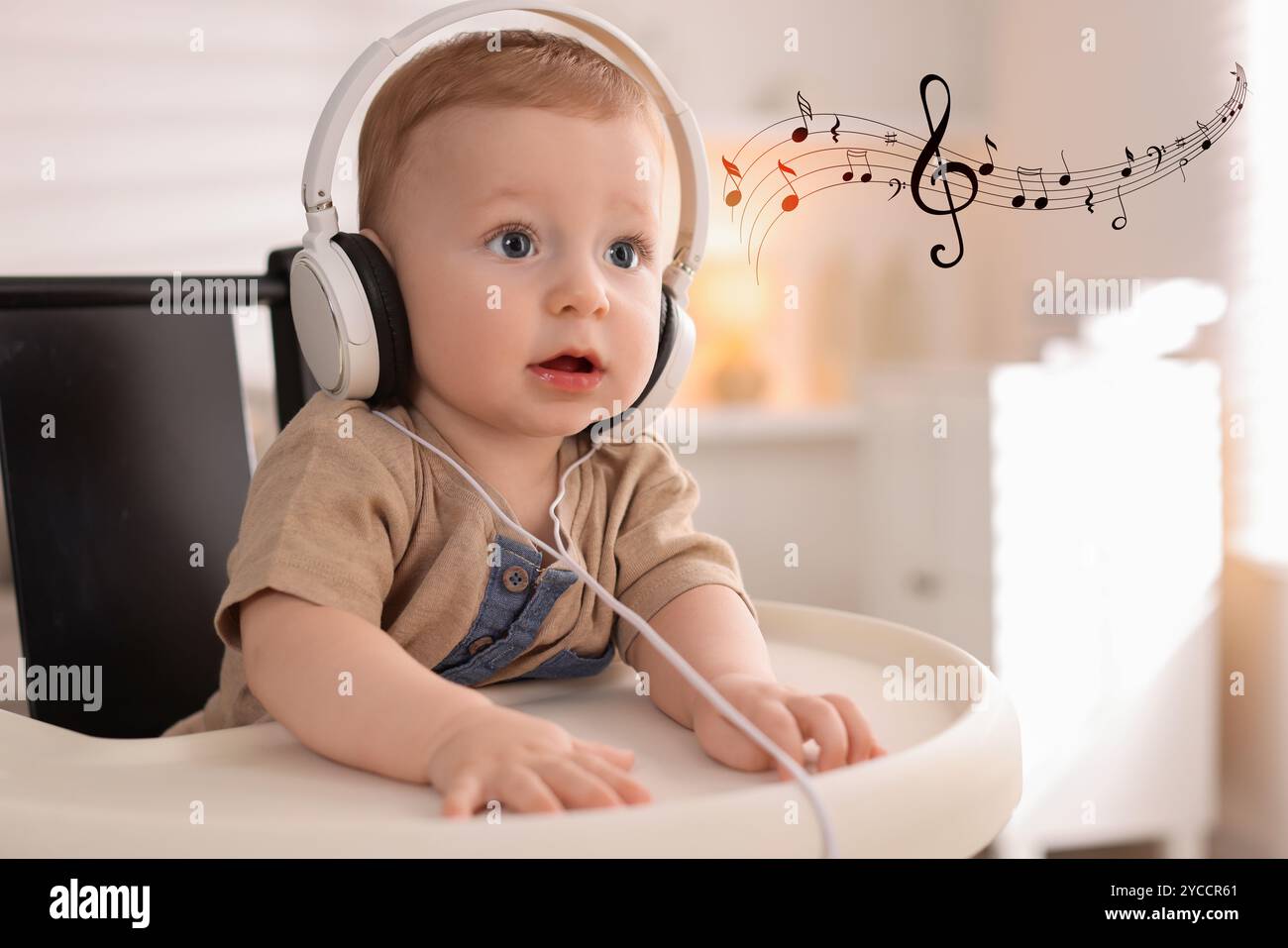Cute little baby with headphones on high chair at home. Music notes ...