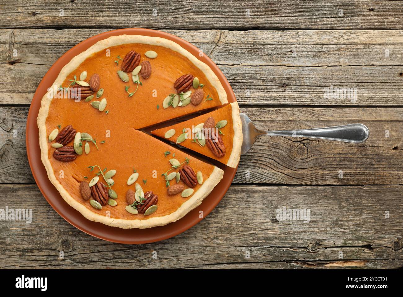 Tasty homemade pumpkin pie and server on wooden table, top view Stock ...