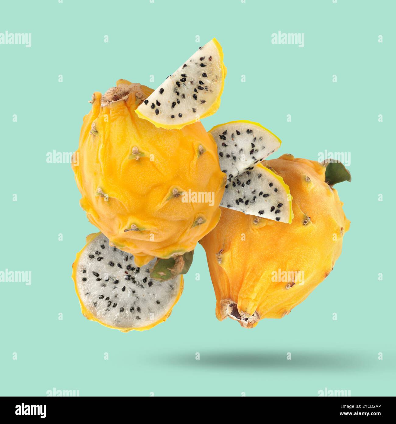 Yummy yellow pitaya fruits falling on turquoise background Stock Photo ...