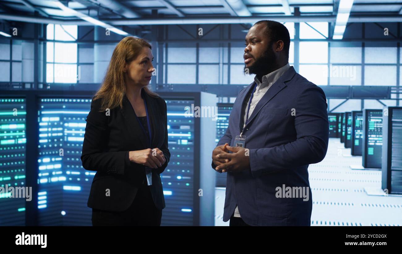 African american expert and coworker looking at holograms in data ...