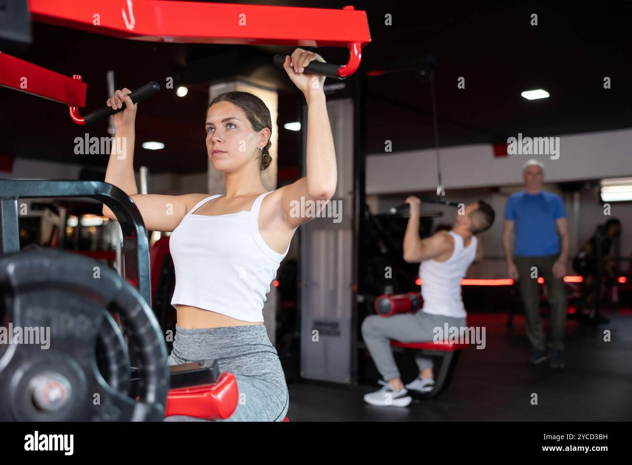 Girl doing strength training in gym, exercising upper body muscles on ...