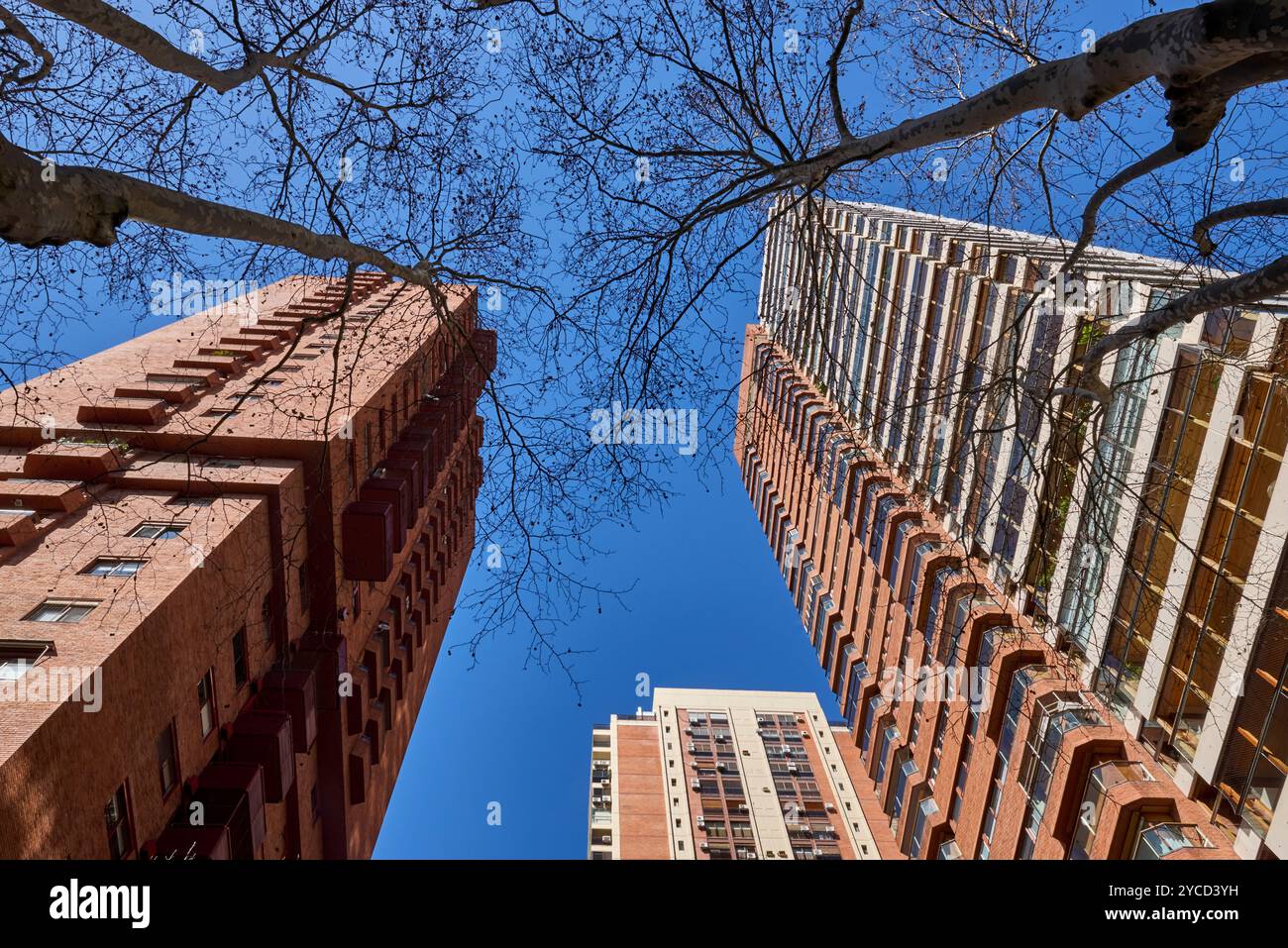 Bottom view of three high residential brick buildings with balconies ...