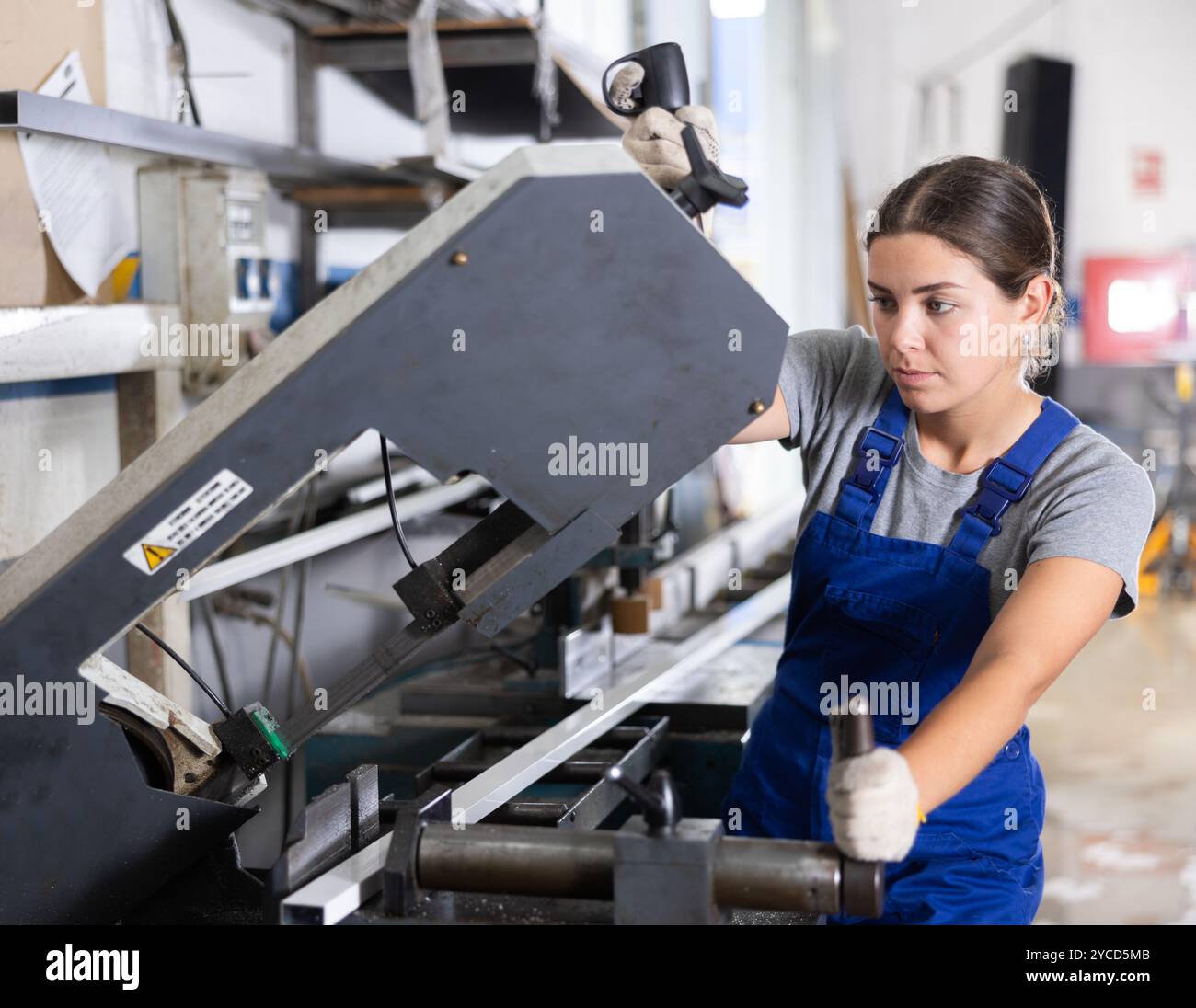 Female machinist operating industrial profile cutting machine Stock ...