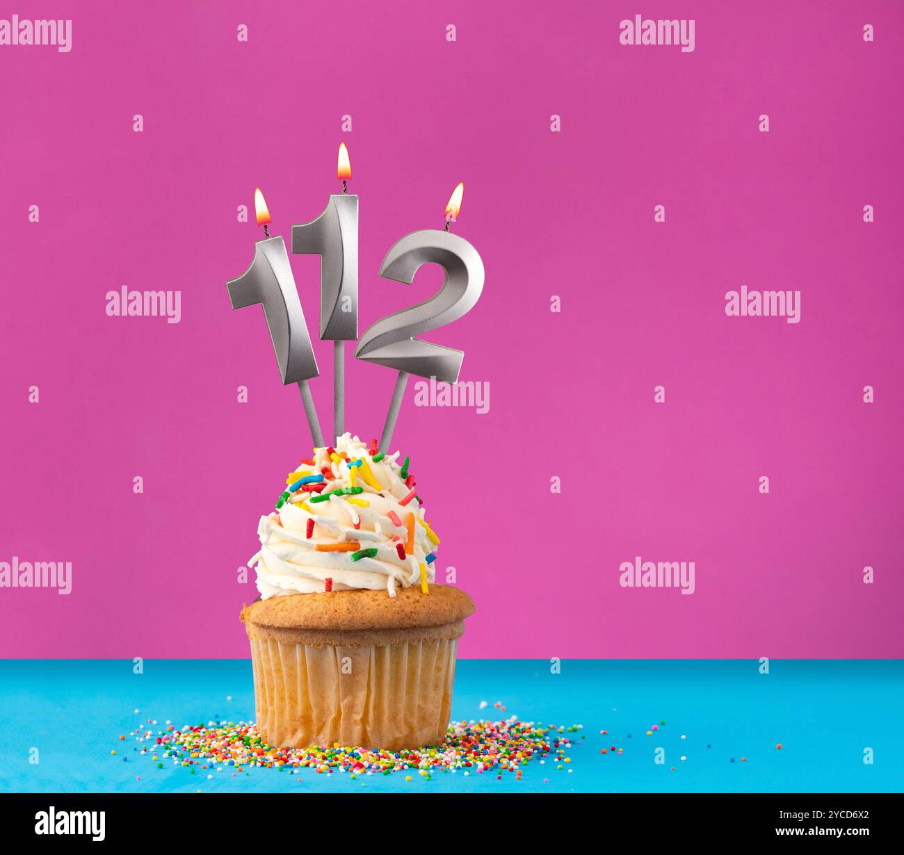 Lit birthday candle with the number 112 - Celebration card on violet ...